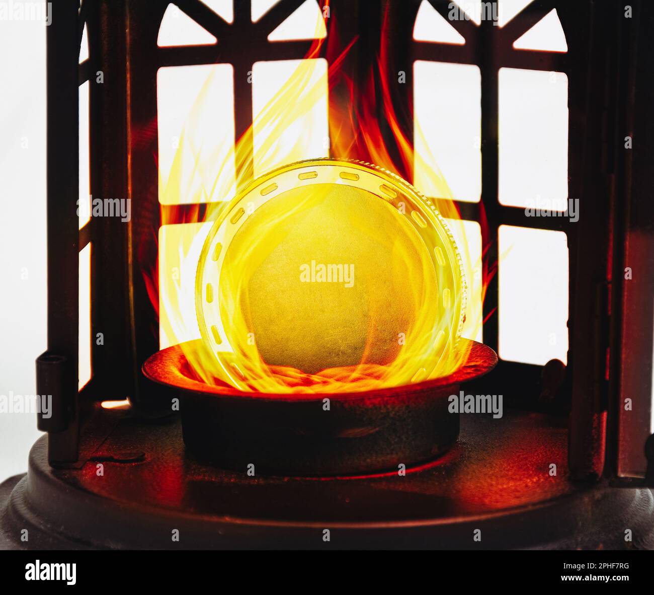 Blank gold coins with burning fire in a metal pedestal of lantern with ...