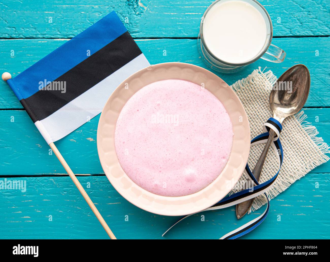 Semolina foam sweet food in bowl and glass of milk on blue wood board ...