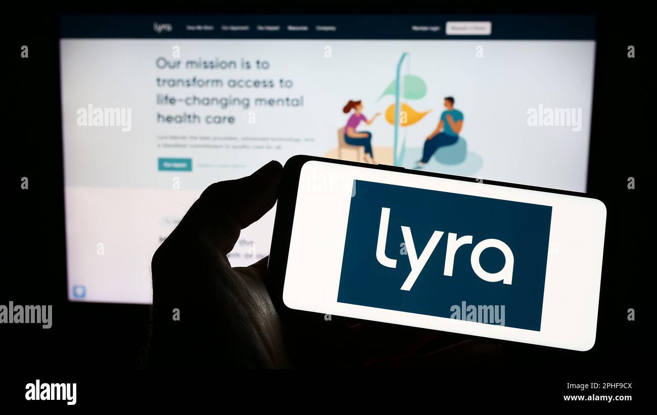 Person holding mobile phone with logo of American mental health company ...