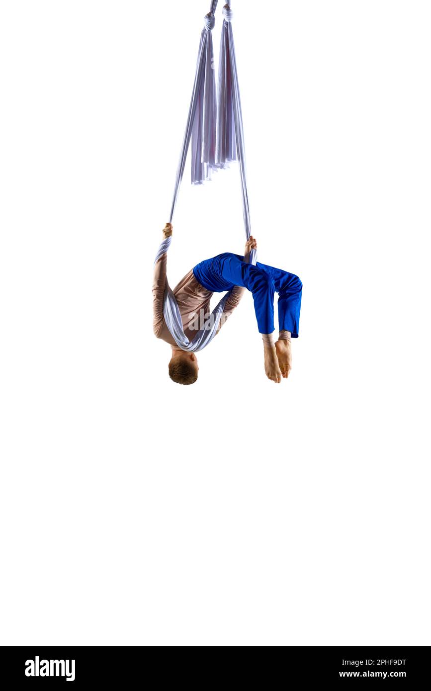 Dynamic image of young man, professional, flexible aerial gymnast doing ...