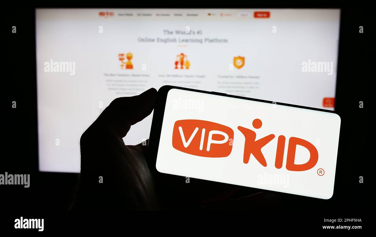 Person holding mobile phone with logo of e-learning company VIPKid on ...