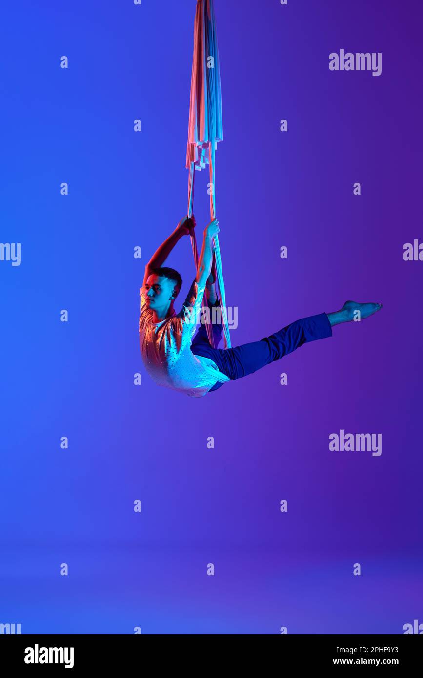 Artistic performance. Young man, acrobat training with aerial ribbons ...