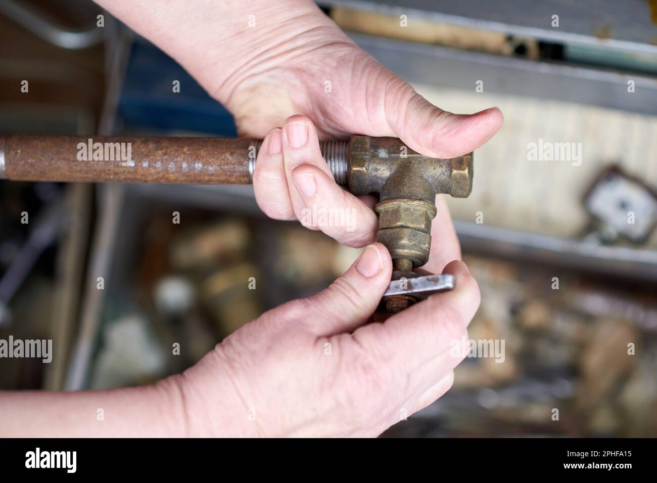 A man is holding an old water pipe valve in his hands Stock Photo - Alamy