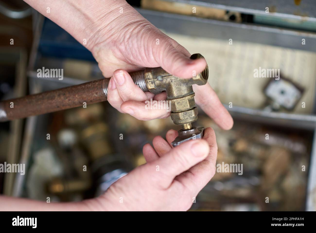 A man is holding an old water pipe valve in his hands Stock Photo - Alamy