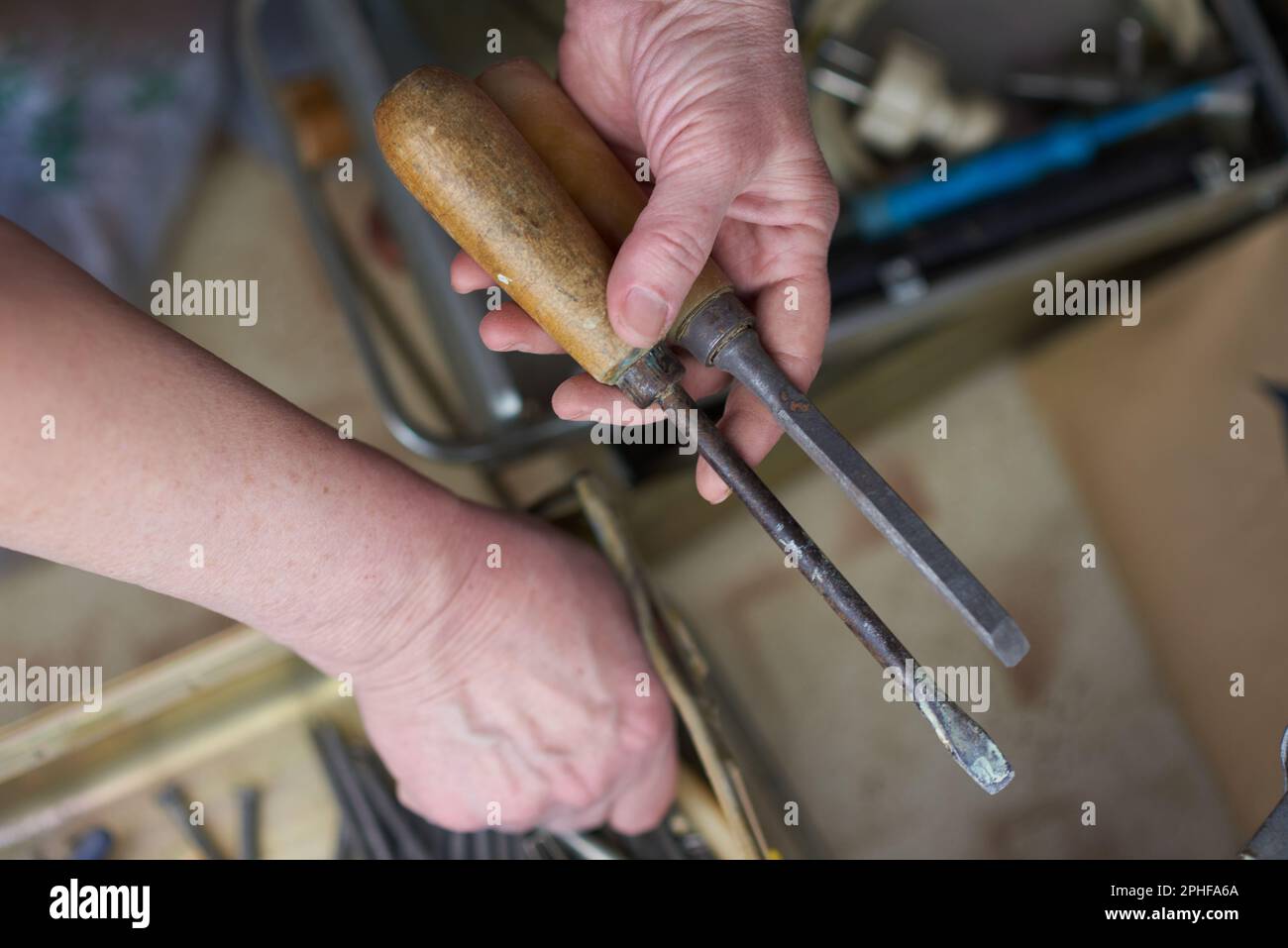The master holds a set of tools in his hands - a chisel and a ...