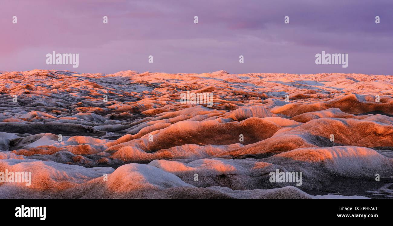 Midnight sun on the ice sheet. The brown sediment on the ice is created ...
