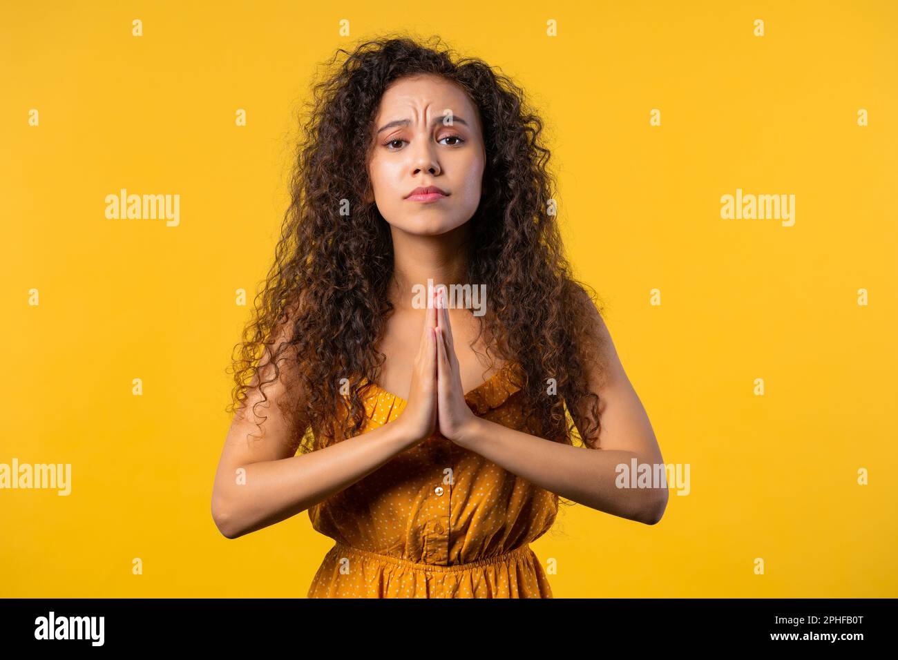 Cute woman praying, begs to apologize her, she is guilty. Yellow ...