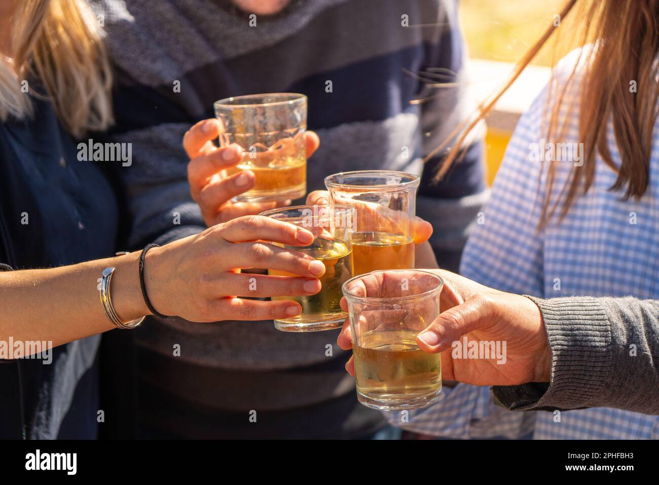 Four hands clinking cocktail glasses hi-res stock photography and ...
