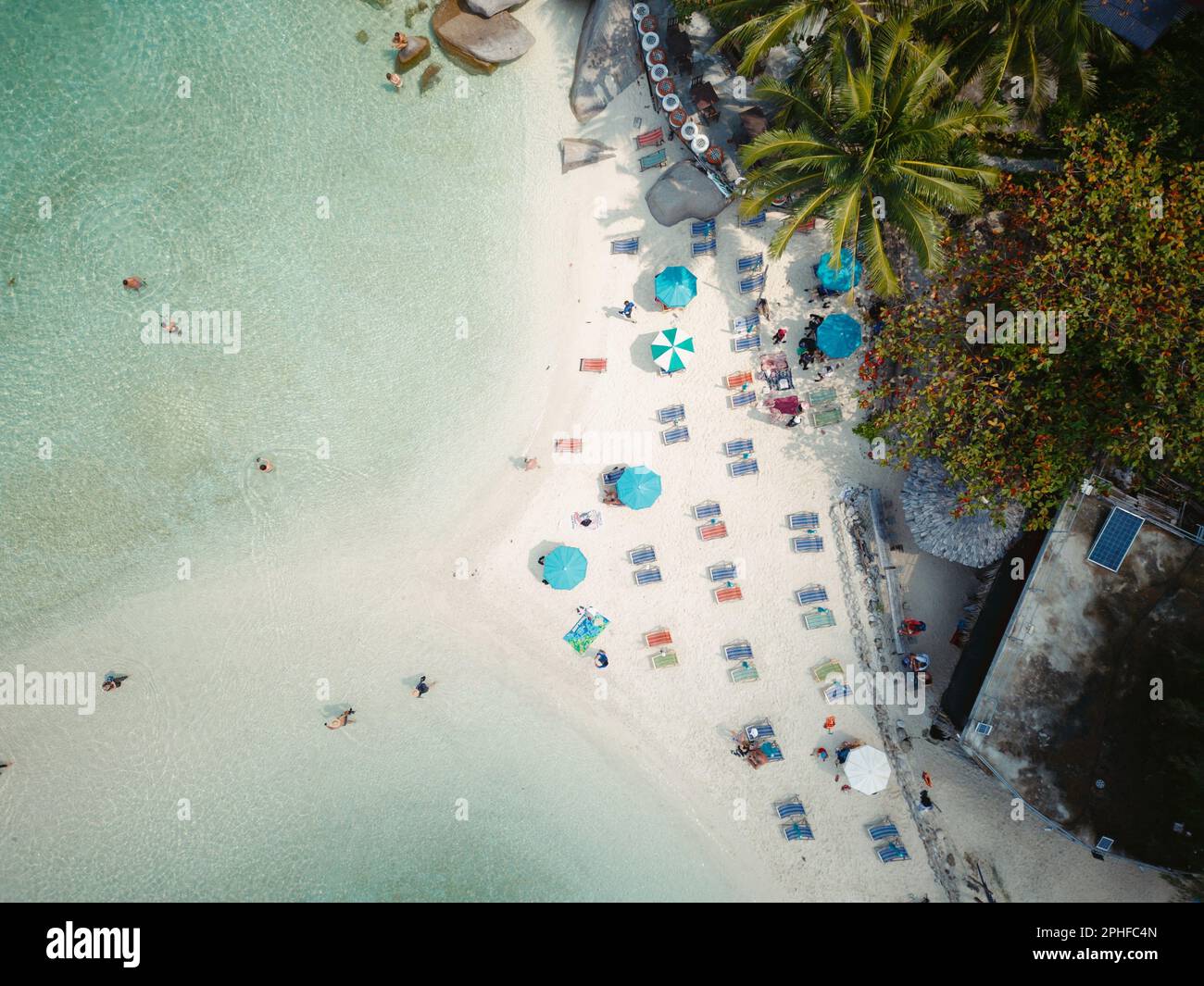 A stunning beach area with people basking in the sun separated by ...