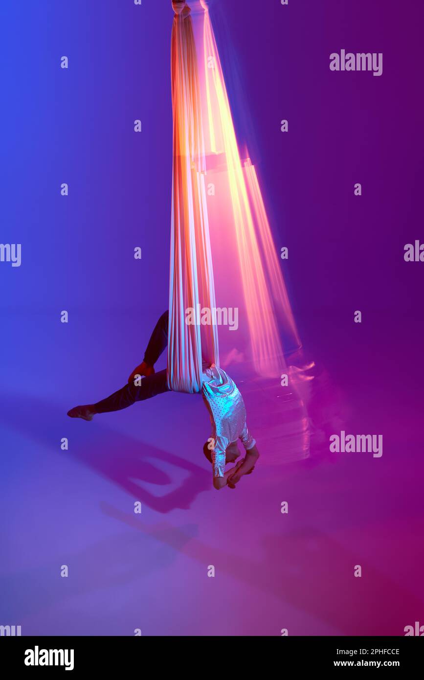 Young man, professional aerial gymnast, acrobat training on aerial ...