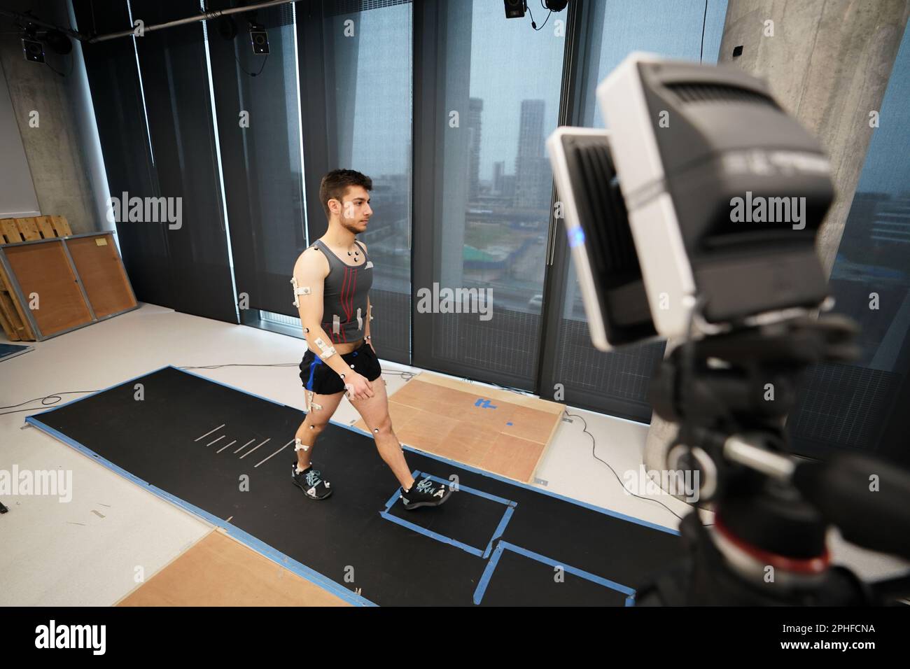 A person walks past motion cameras while covered in sensors during the ...