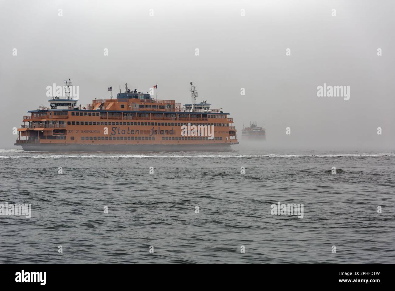 The bright orange Staten Island Ferry brightens the foggy February ...