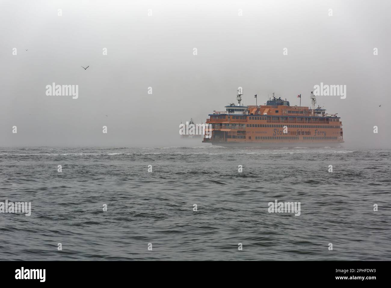 The bright orange Staten Island Ferry brightens the foggy February ...
