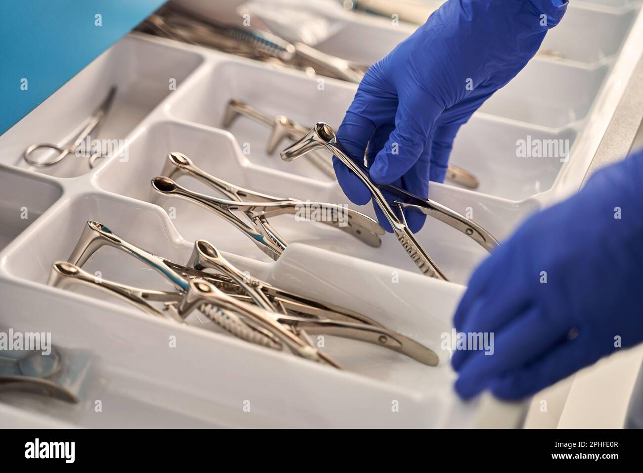 Doctor's hands wearing a disposable medical gloves holding a stainless ...