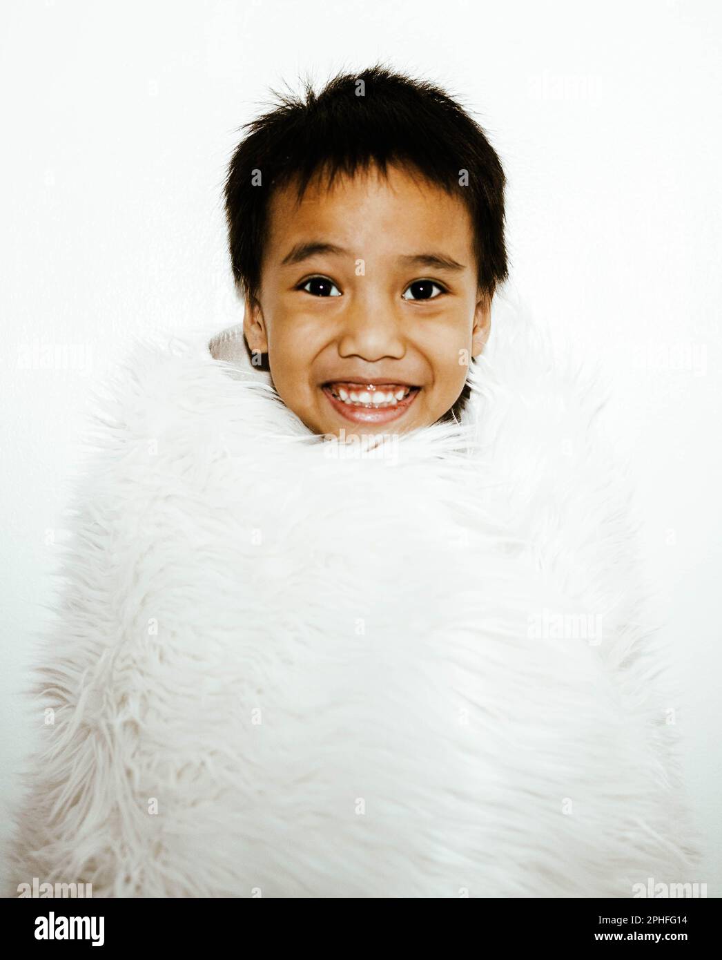 A child wearing a white fur stole standing on a white background Stock ...