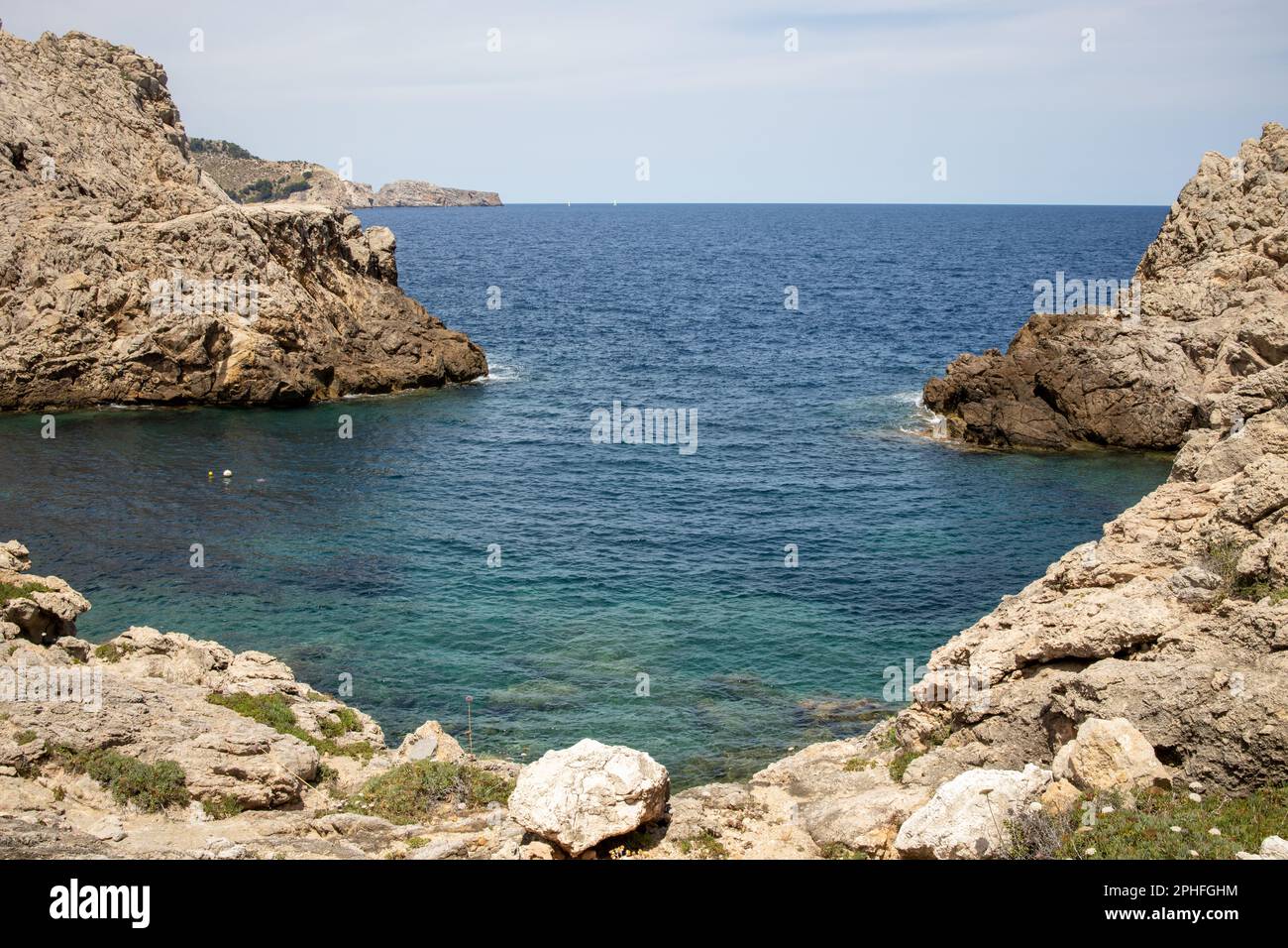 An aerial view of a tranquil cove, featuring rocky cliffs and an ...