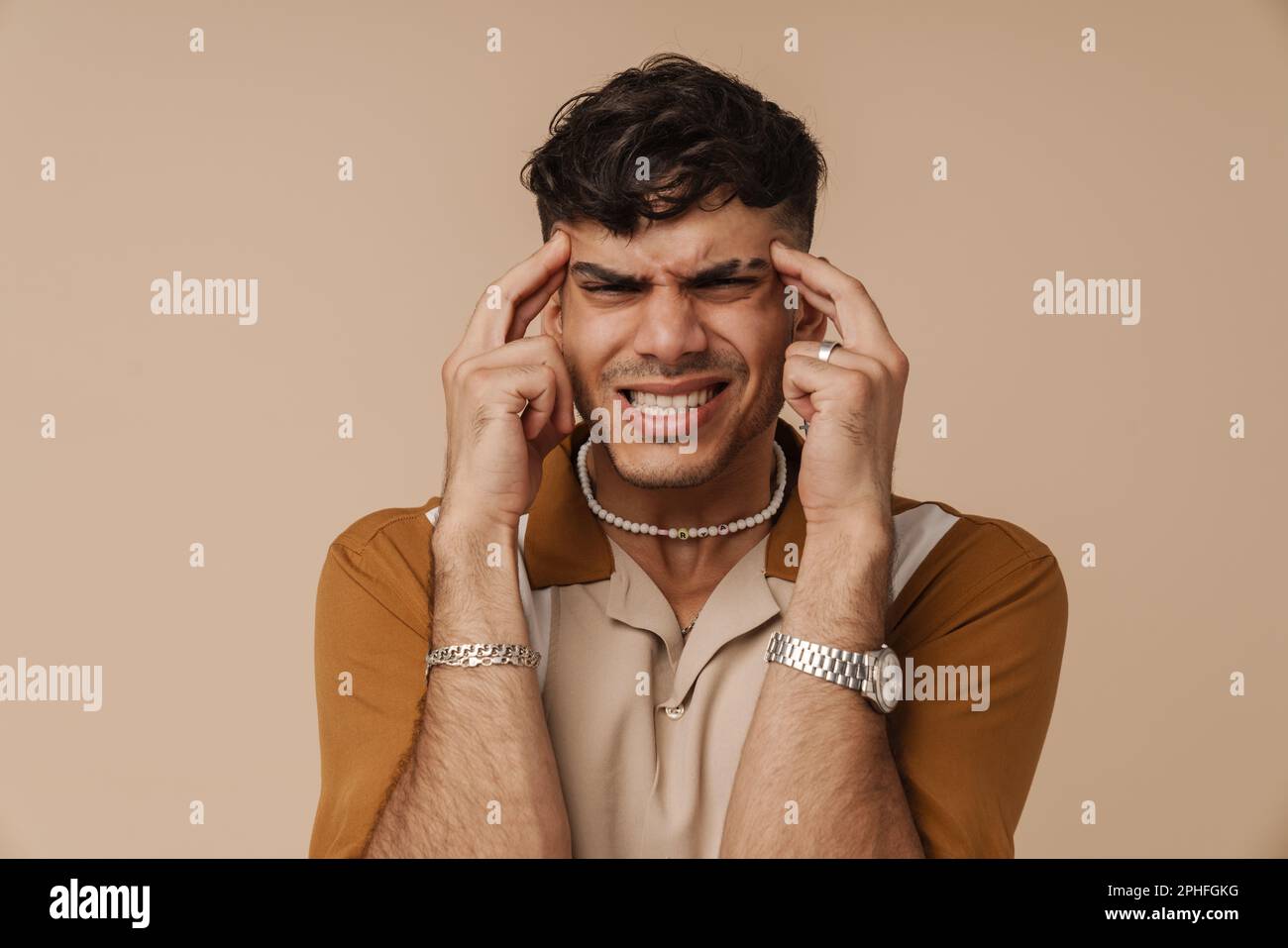 Young handsome stylish tense man with closed eyes and clenched teeth ...