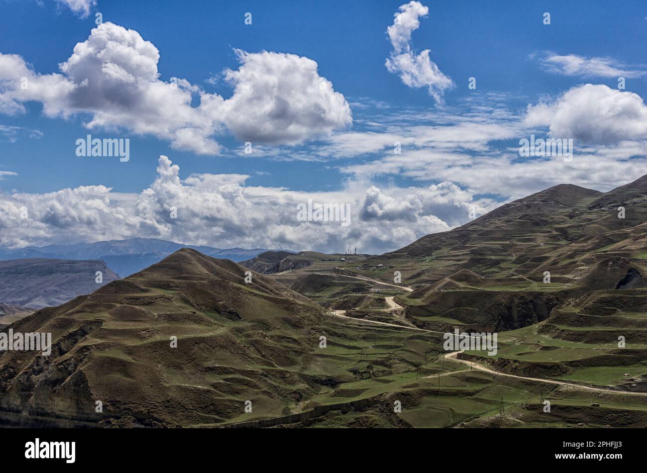 A scenic view of a mountainous landscape with rolling hills covered in ...