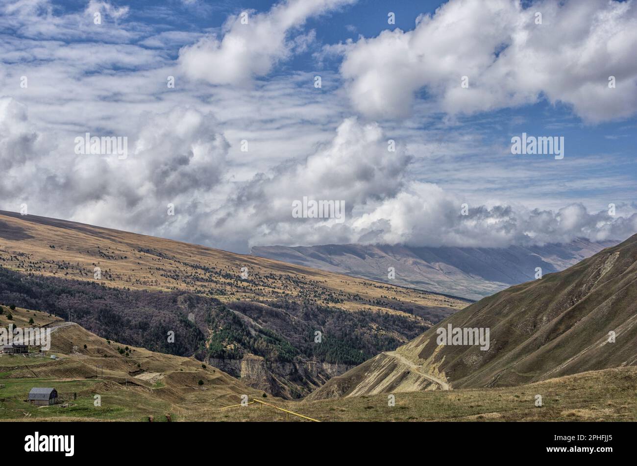 A scenic view of a mountainous landscape with rolling hills covered in ...