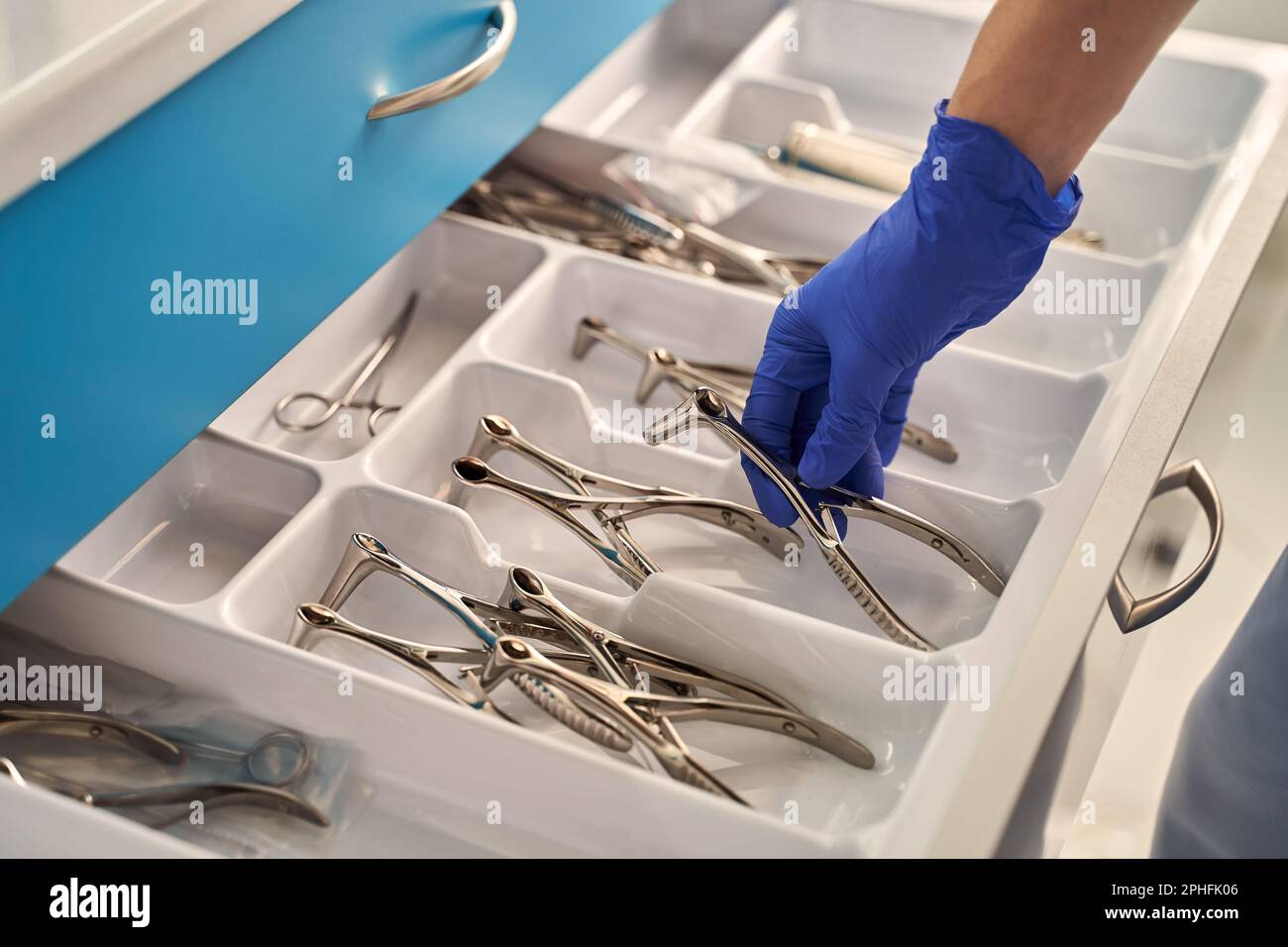 Doctor's hands wearing a disposable medical gloves holding a stainless ...
