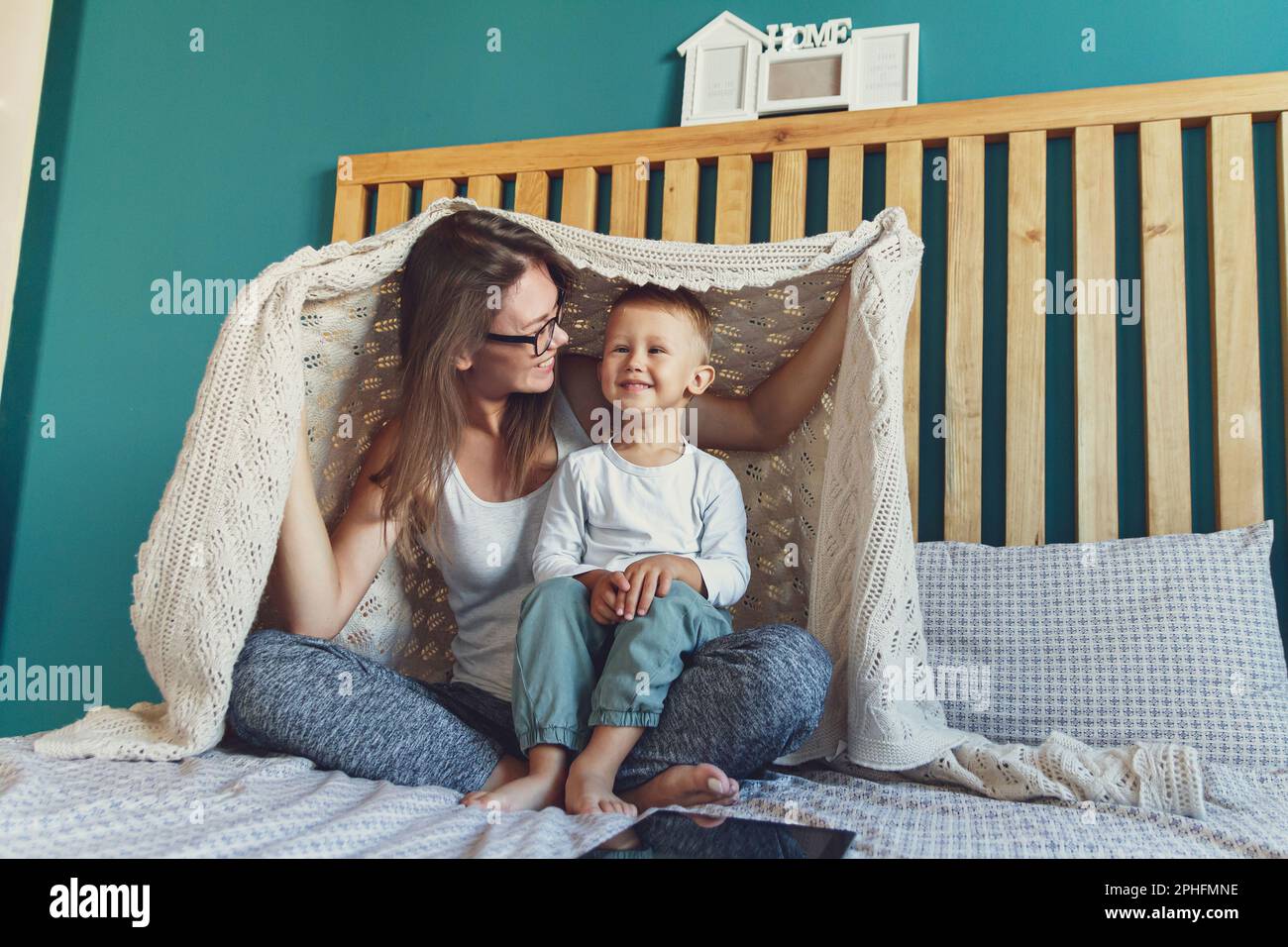 mom and child have fun in the bedroom on the bed under the blank Stock ...
