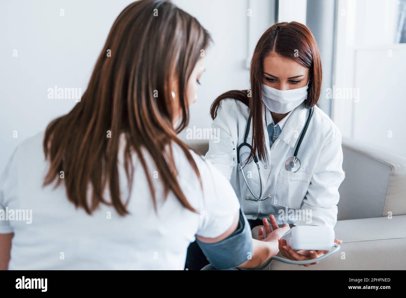 Measuring blood pressure. Young woman have a visit with female doctor ...