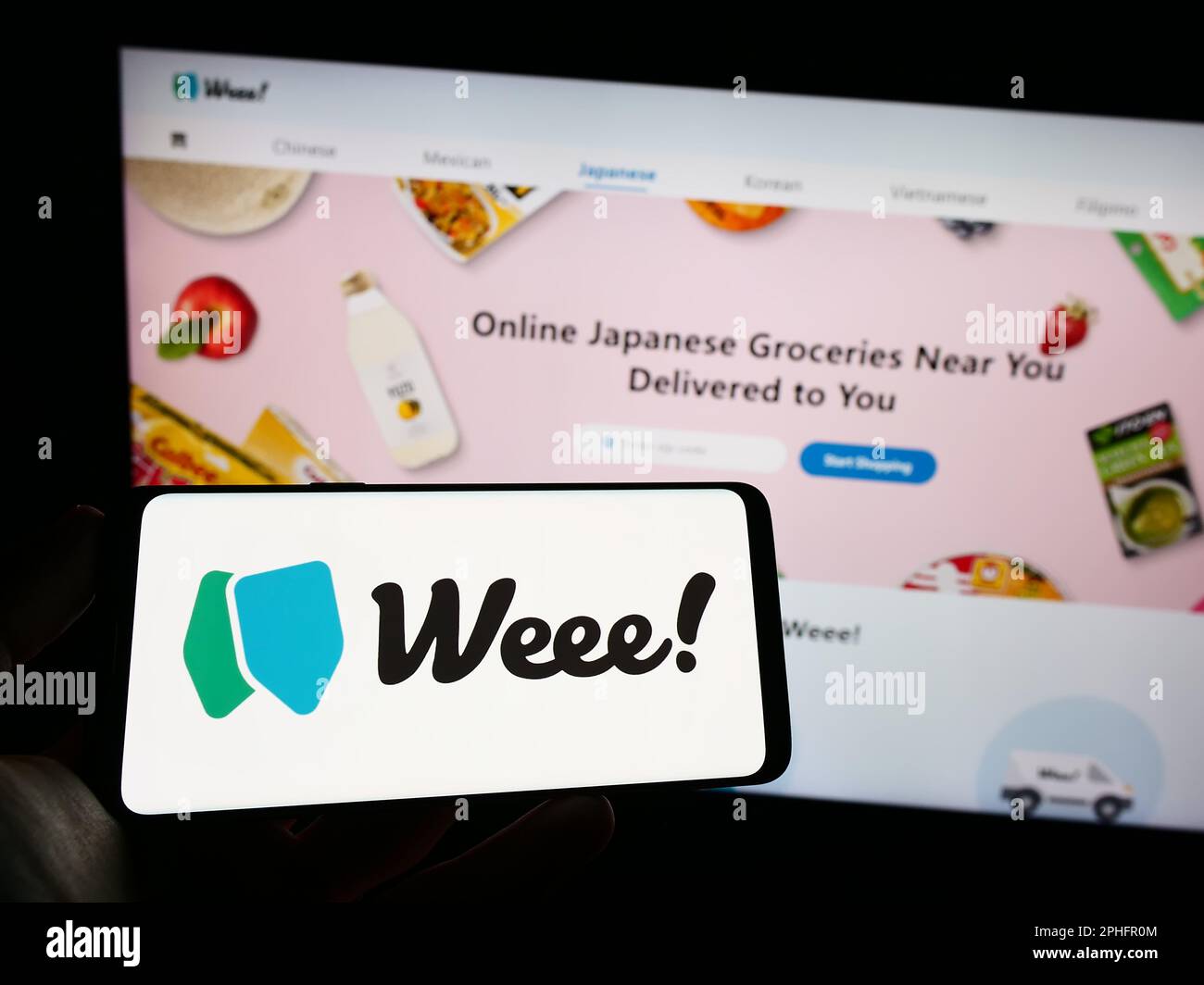 Person holding cellphone with logo of American grocery delivery company ...