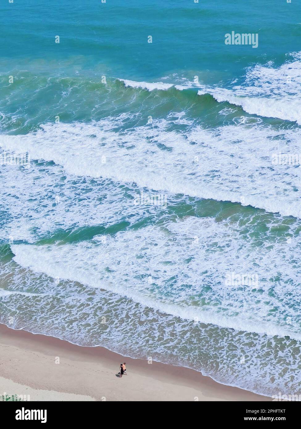 An aerial view of two people walking on a sandy beach Stock Photo - Alamy