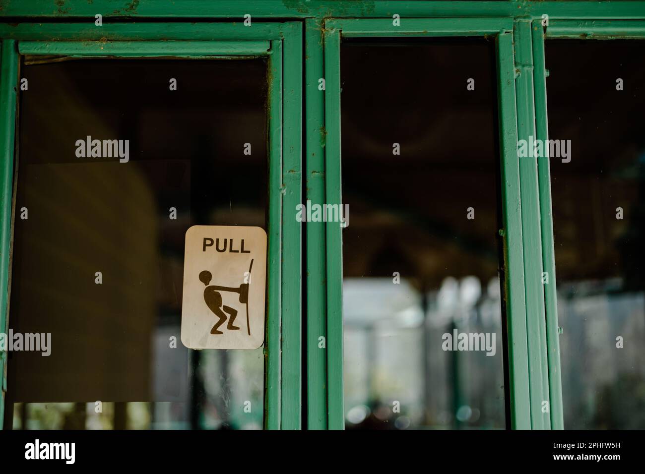 A closeup of a pull sign on a glass door of a cafe Stock Photo - Alamy
