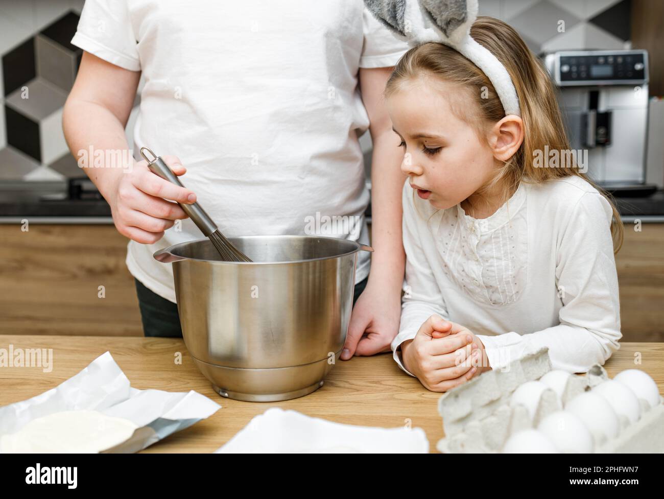Overweight Teenager boy with no face mixing dough, girl in bunny ears ...