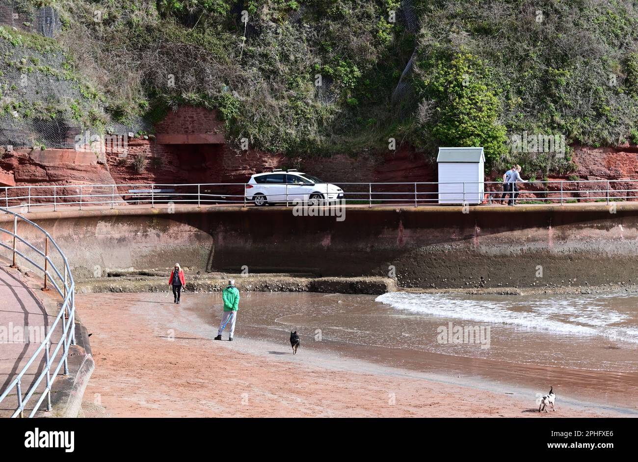 A beach hut and car moving along the narrow promenade at Goodrington ...