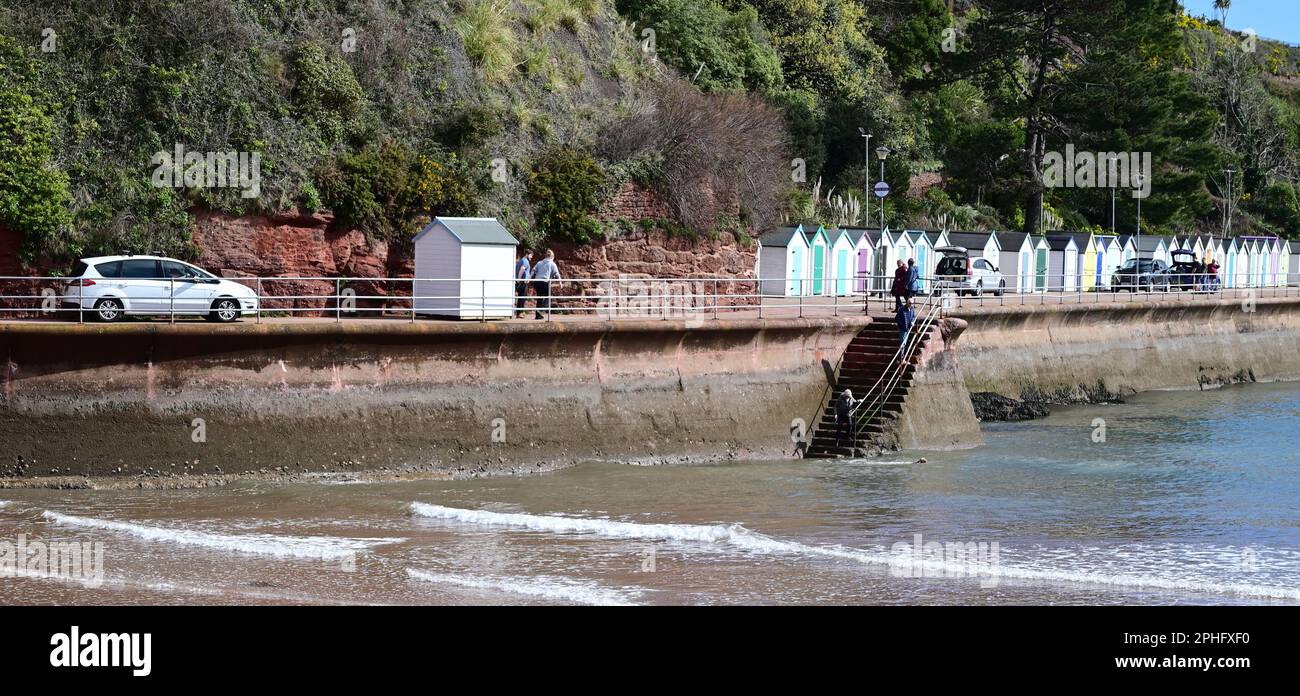 A beach hut and car moving along the narrow promenade at Goodrington ...