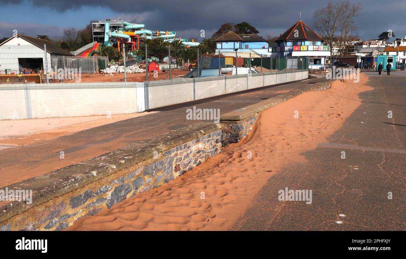 Winter sunlight and windblown sand piled up against a wall on the ...