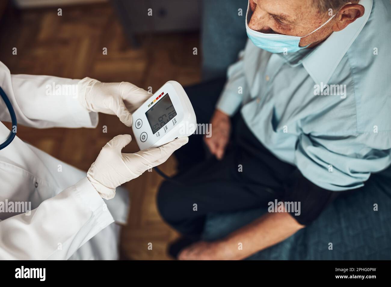 Doctor carying out blood pressure test and heart rate of senior man ...