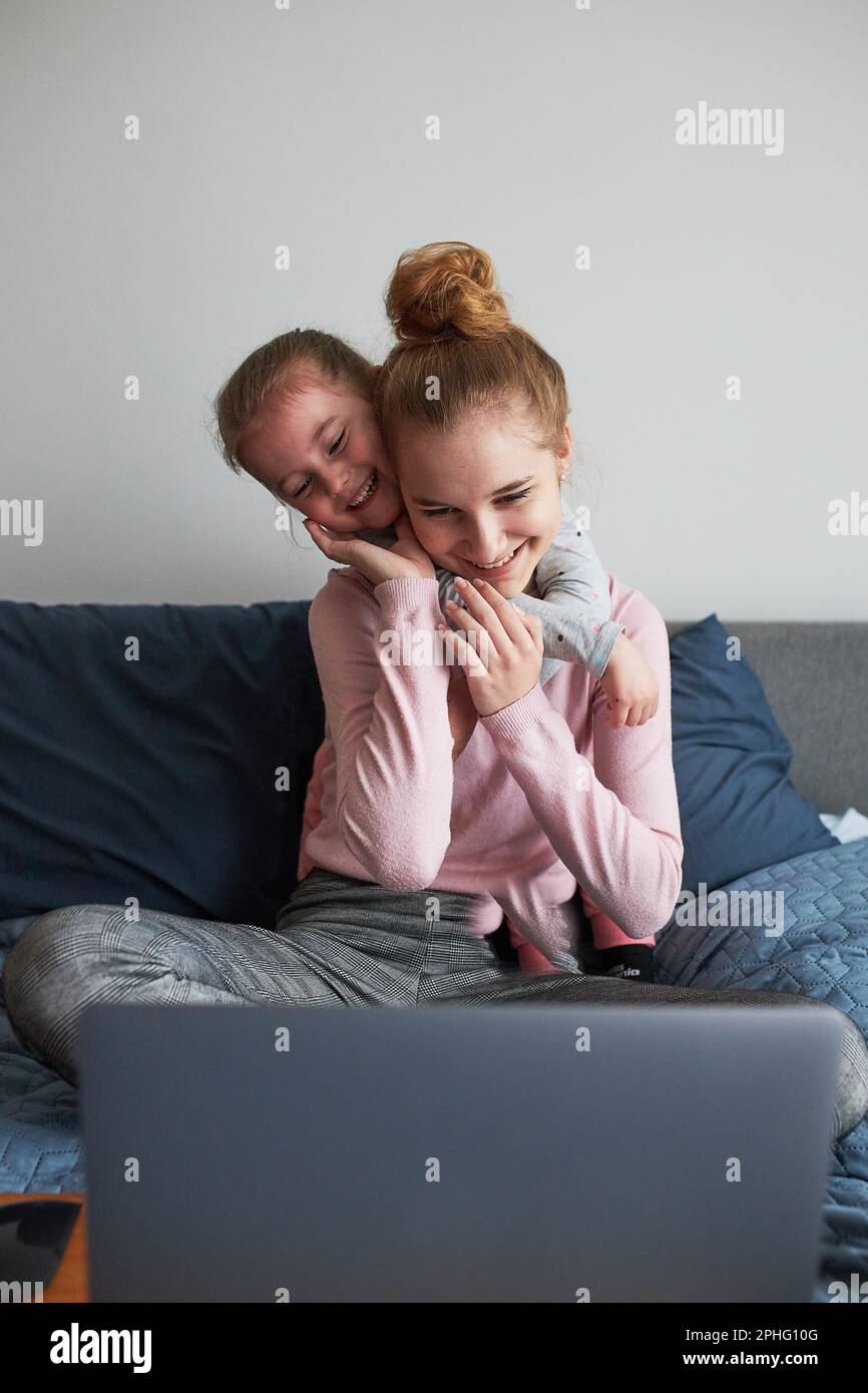 Grandchildren teenage girl and her younger sister talking on video call ...