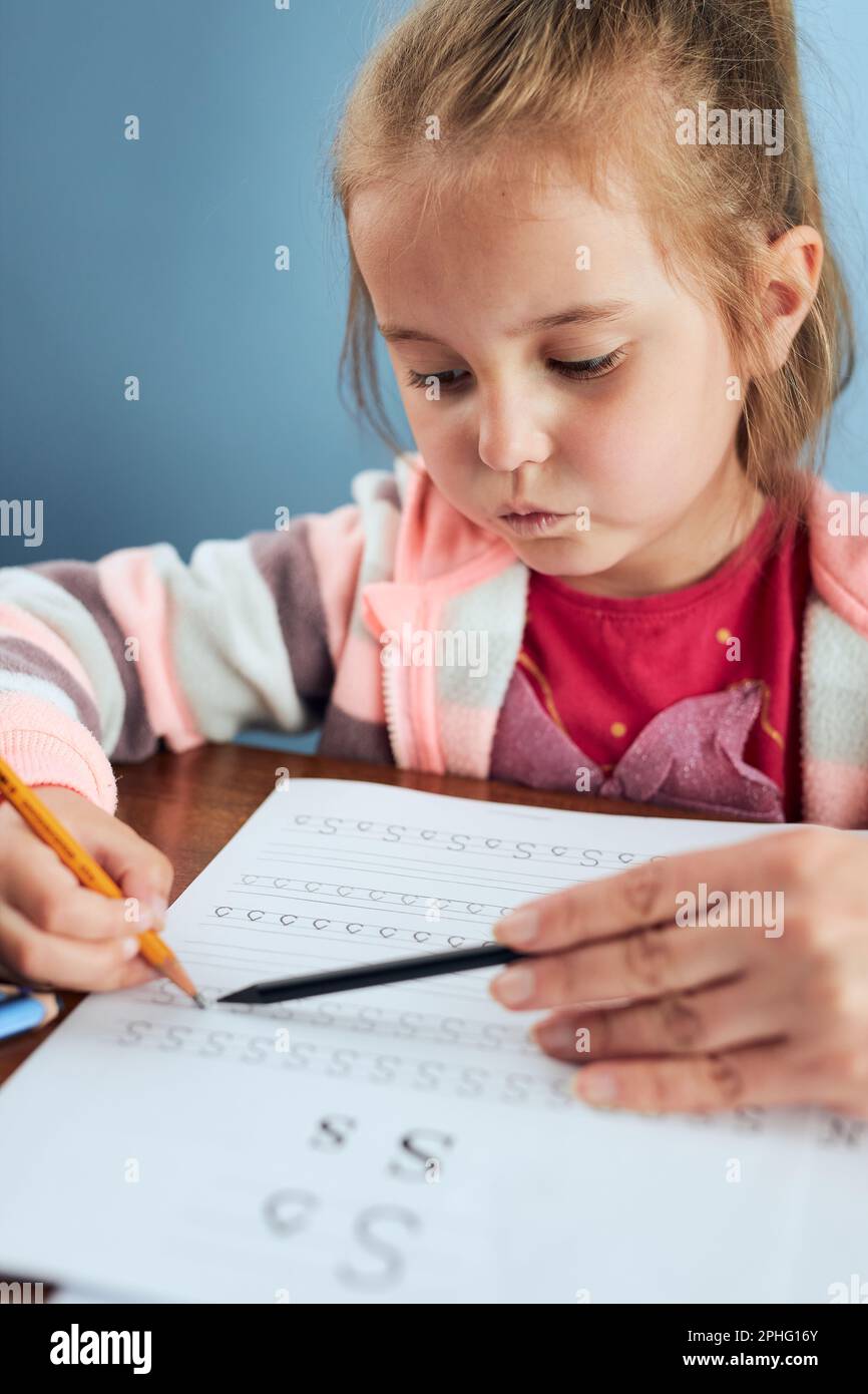 Little girl preschooler learning to write letters with help of her ...