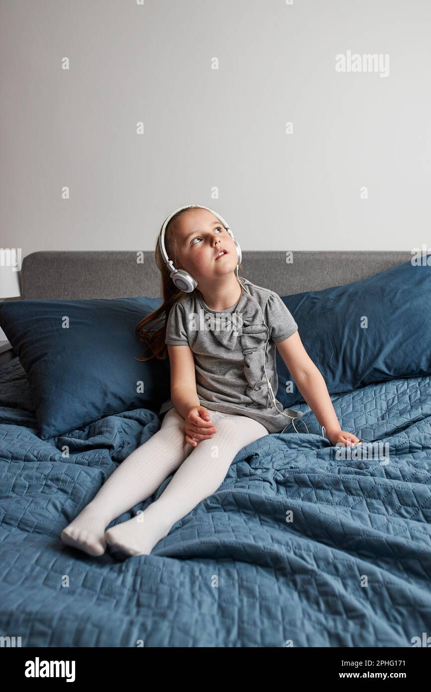 Little girl singing holding headphones cord imitating herself a real ...