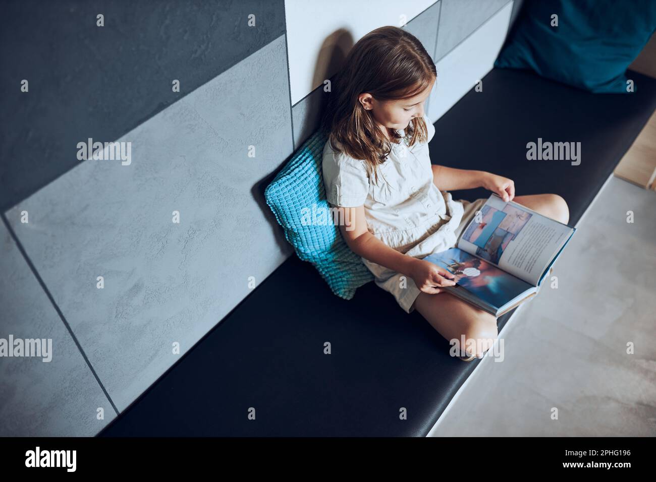 Schoolgirl reading book in school library. Primary school pupil is ...