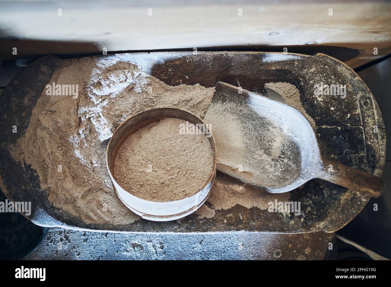 Sifting flour. Bolting flour. Flour in wooden bowl. Old rustic kitchen ...