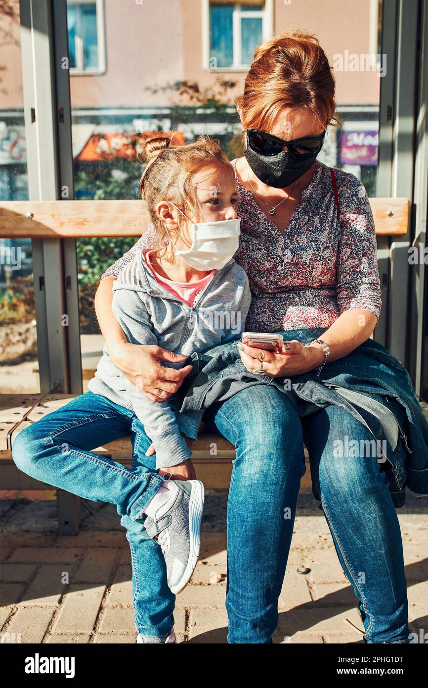 Woman and her child waiting for a bus sitting at bus stop of public ...