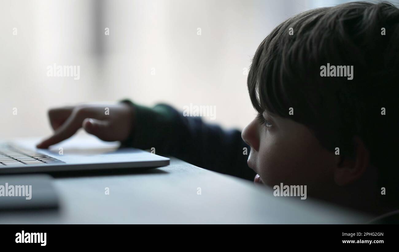 Candid small boy using laptop computer. Child close up face touching ...