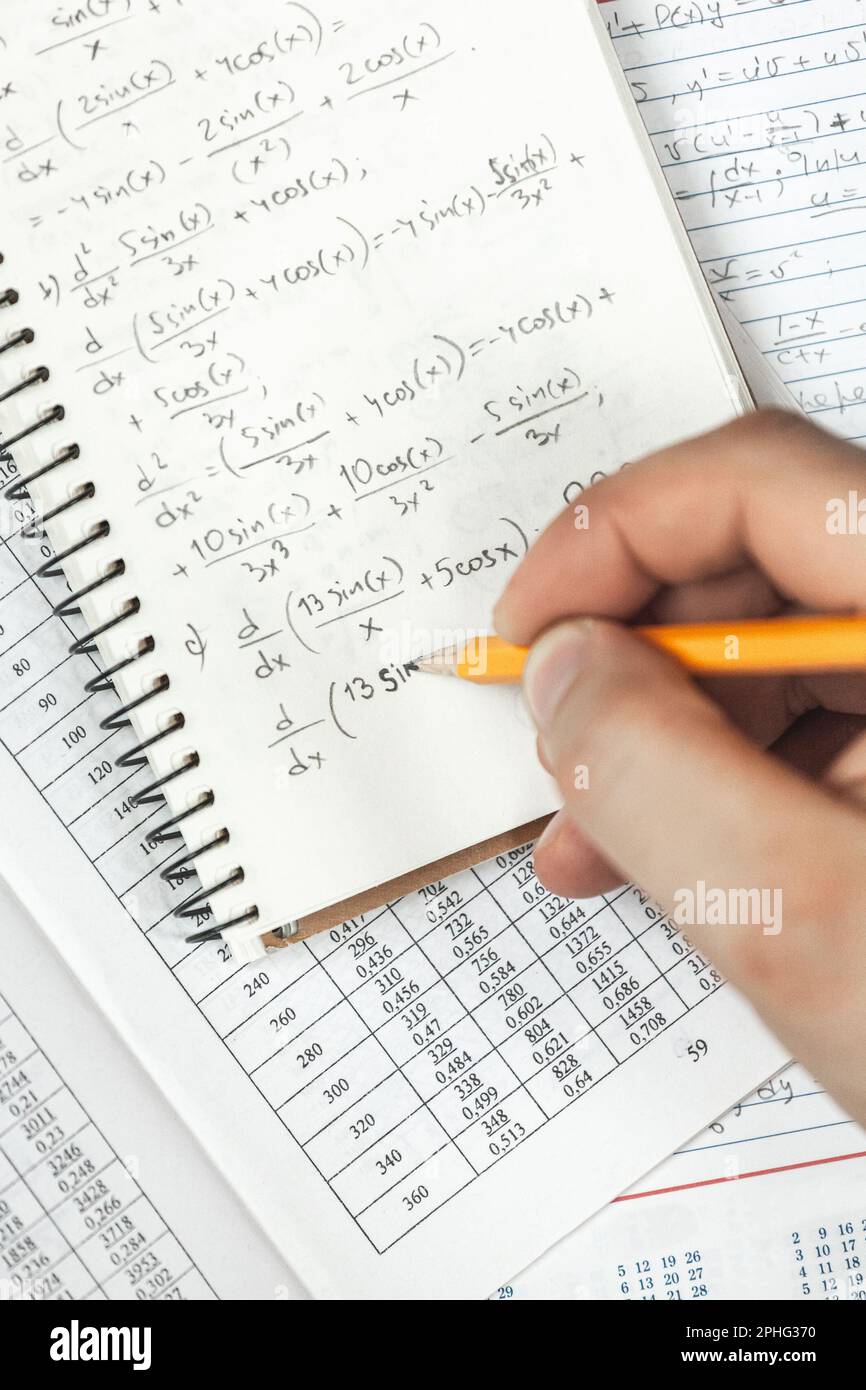 Math formulas are written in pencil in a notebook holding man in Stock ...