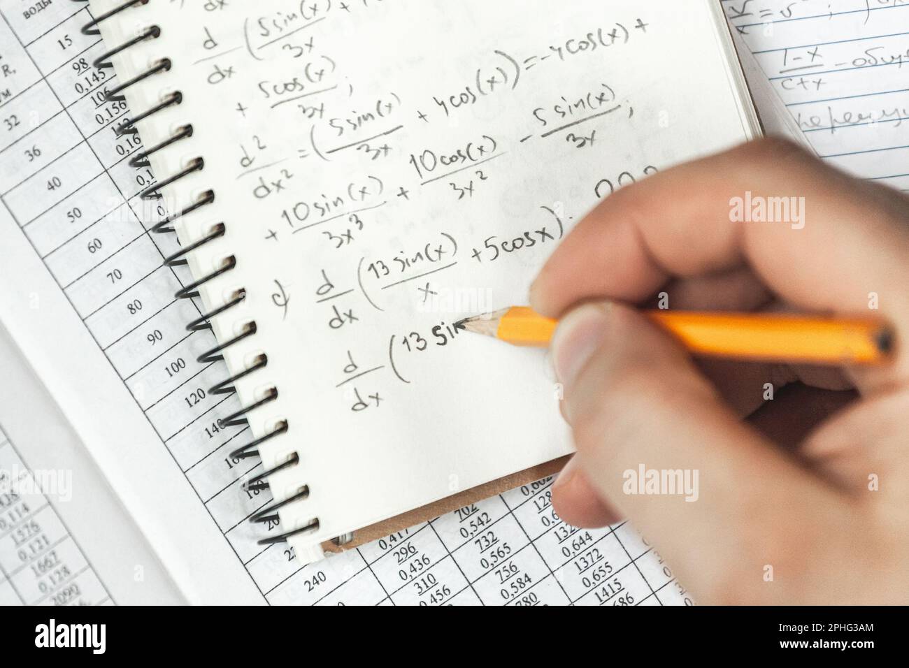 Math formulas are written in pencil in a notebook holding man in Stock ...