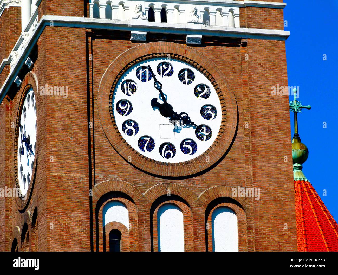 church clock tower closeup detail. black hands. white clock face. brick ...