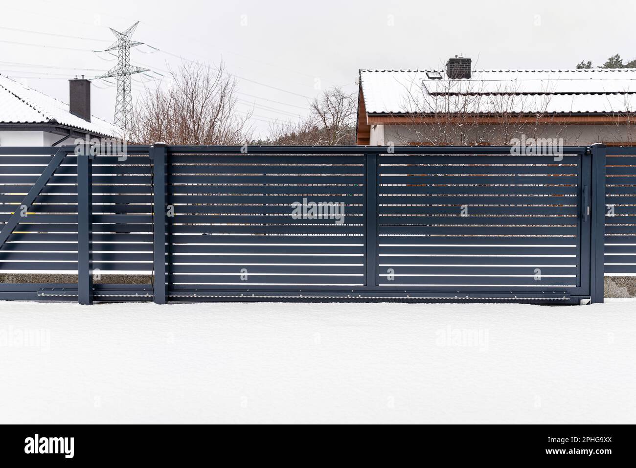 Modern panel fence in anthracite color, visible sliding gate and snow ...