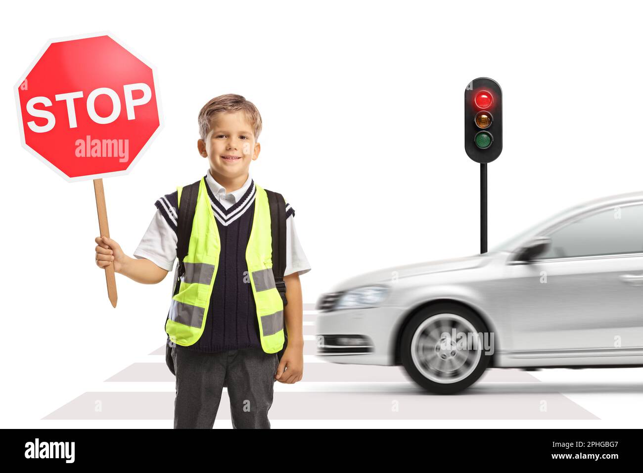 Schoolboy with a safety vest and a stop traffic sign standing at a ...
