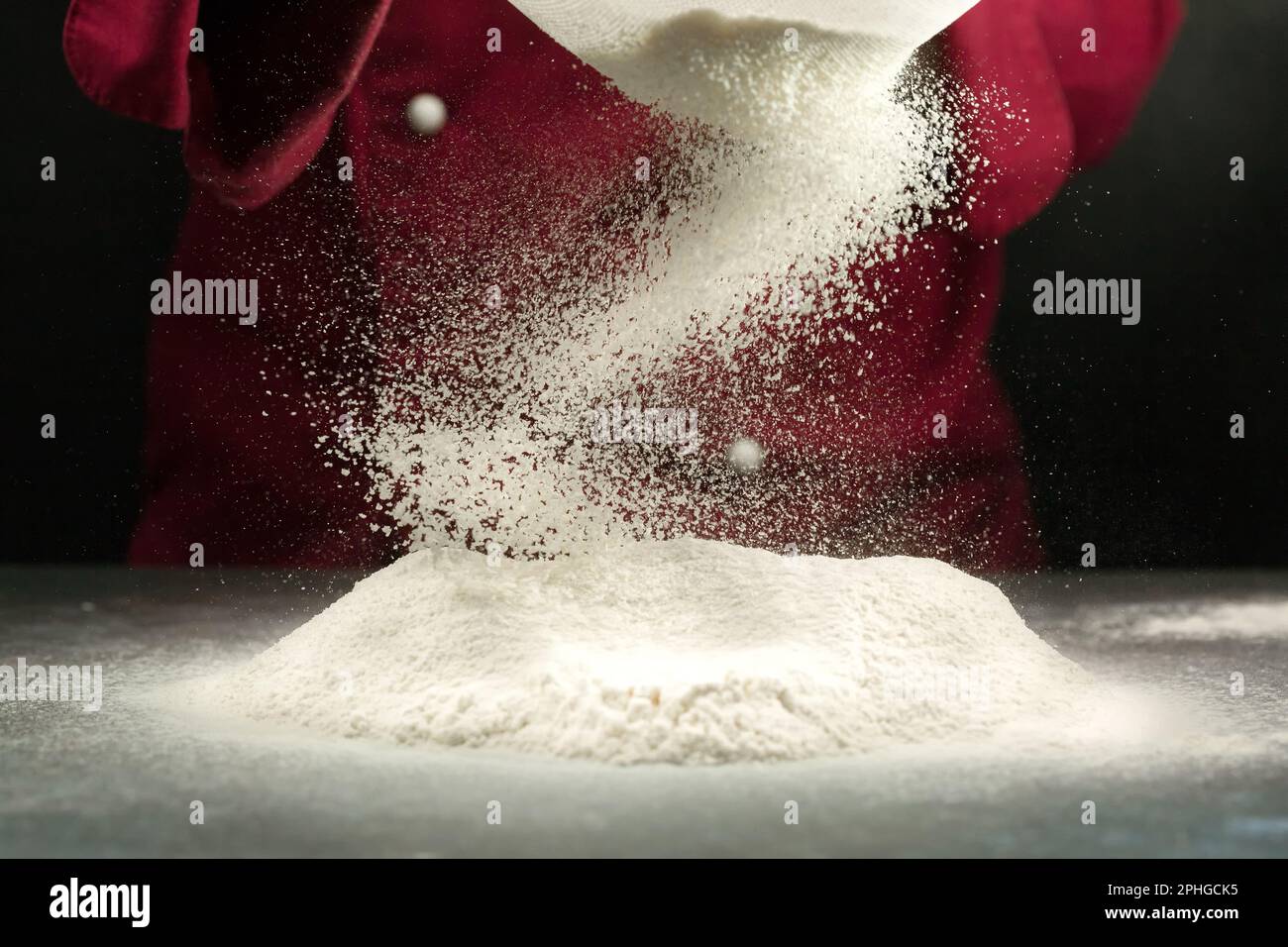 Sifting flour. Chef sifts flour through a sieve Stock Photo - Alamy