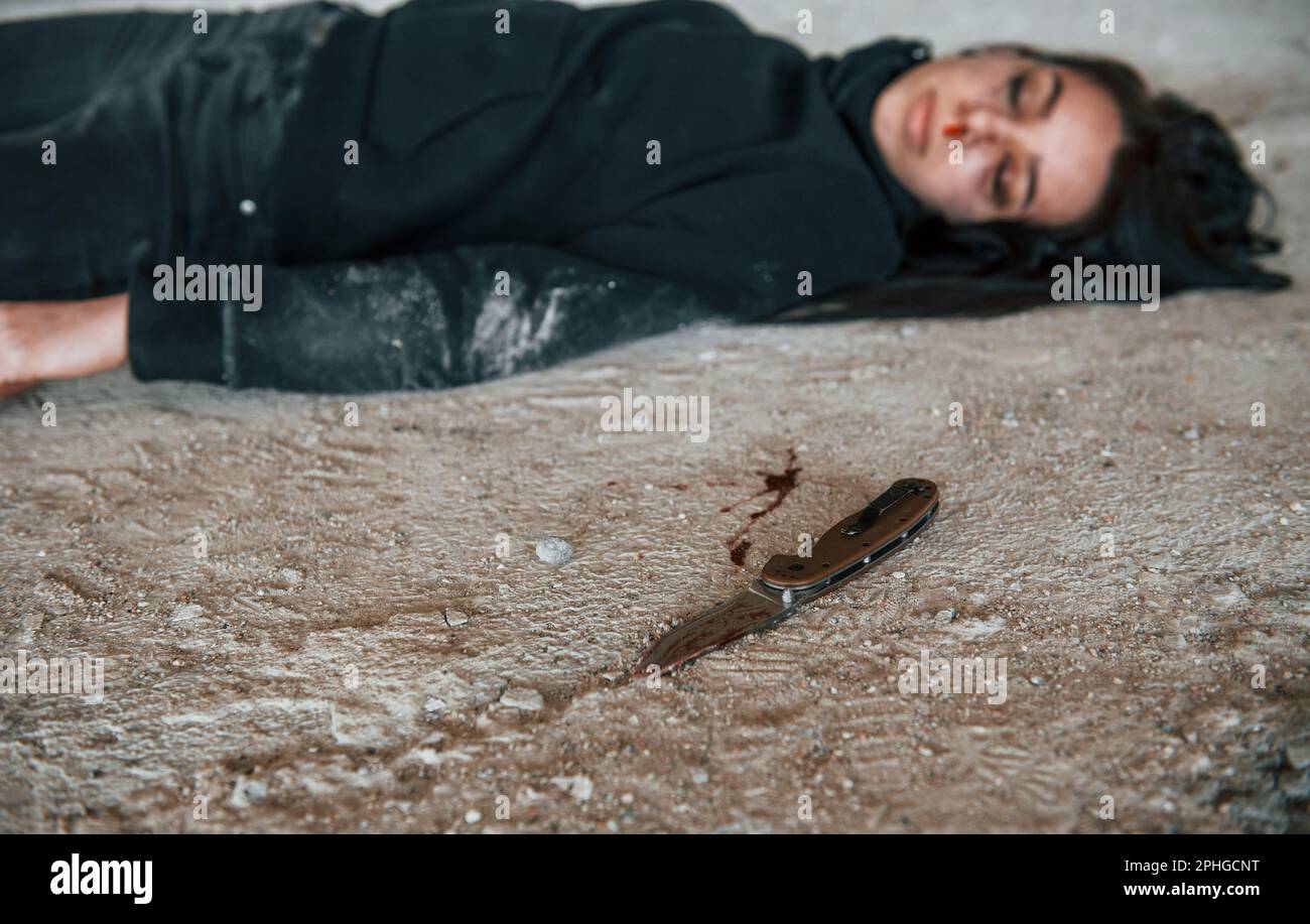 Corpse of female victim of crime lying down on the ground of abandoned ...