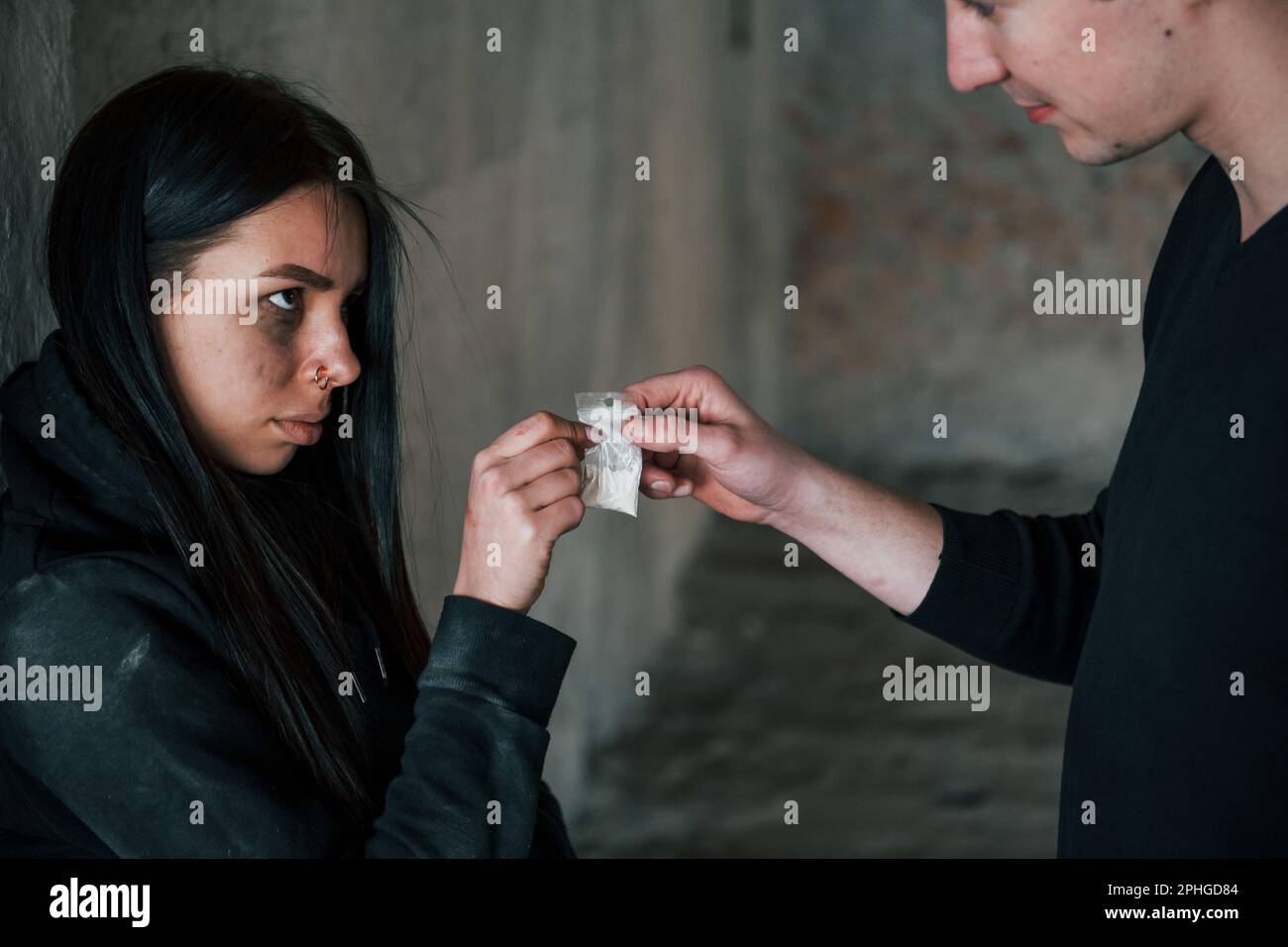 Two people standing with illegal drugs in little package indoors Stock ...