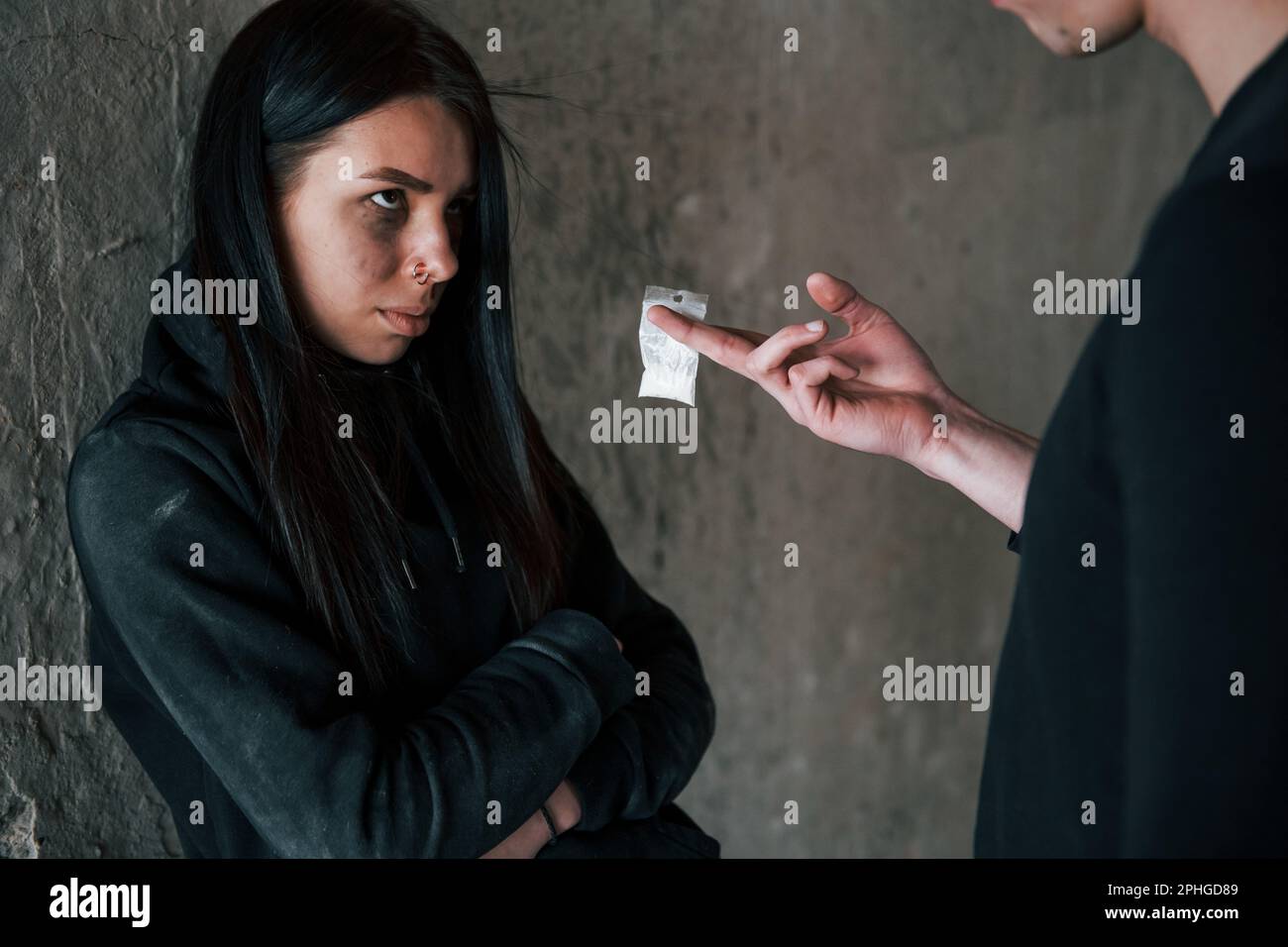 Two people standing with illegal drugs in little package indoors Stock ...
